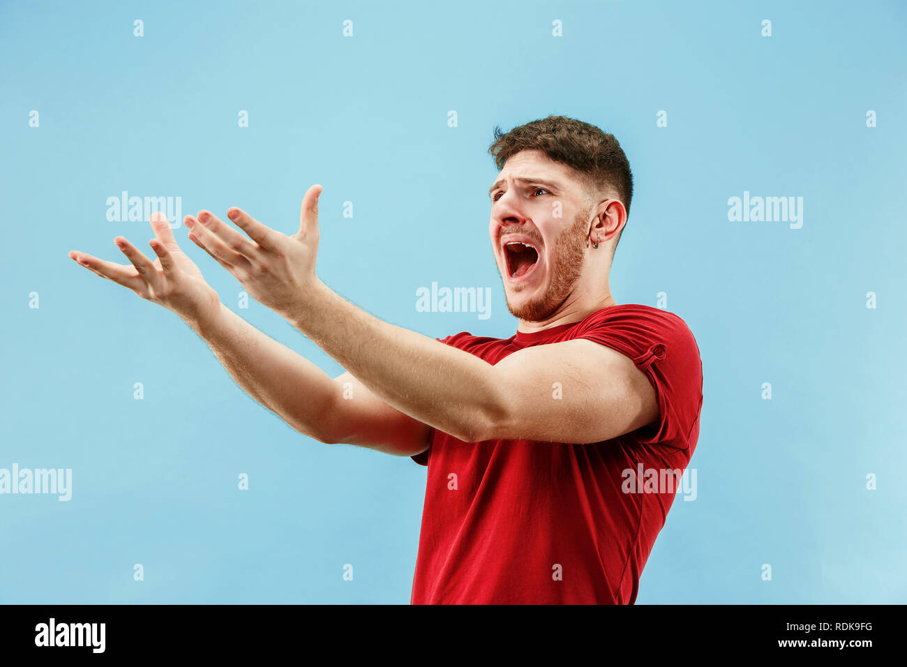 Screaming, hate, rage. Crying emotional angry man screaming on blue ...