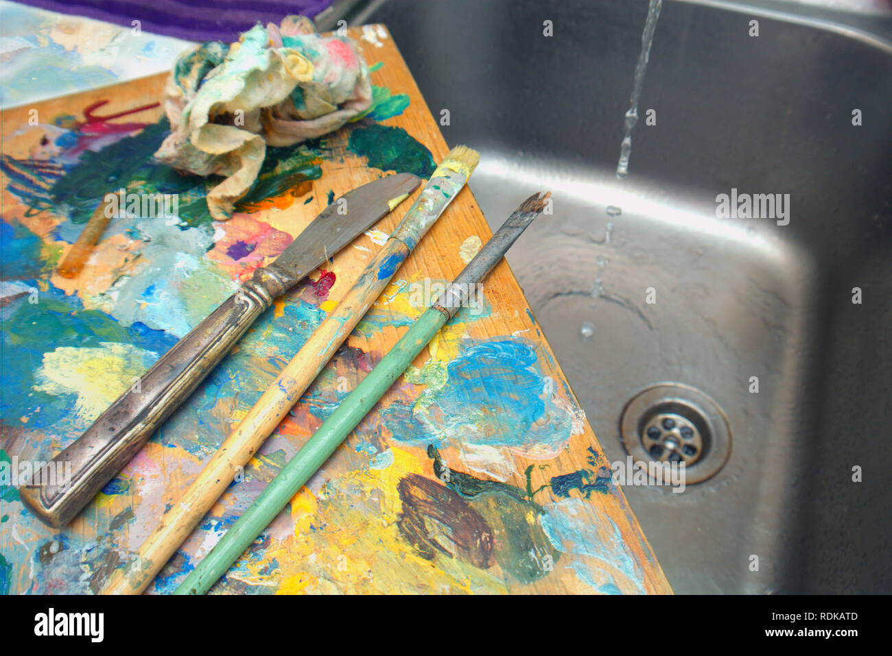 Washing dirty artist palette and painting brushes, a kitchen sink and ...