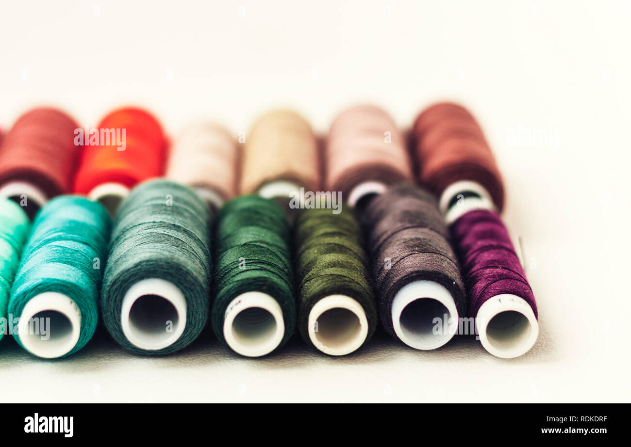 Colored sewing thread coils on white background with copy space for ...