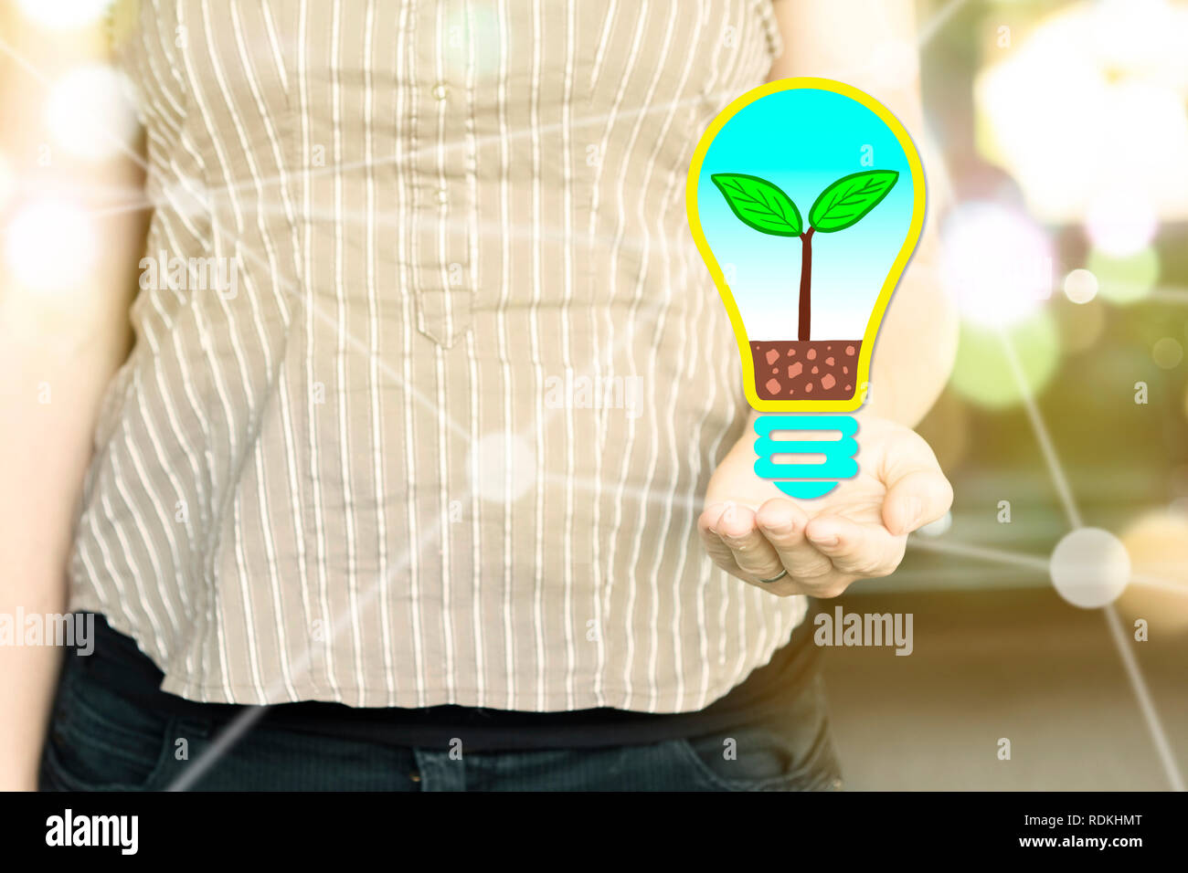 Woman holding a light bulb with a plant growing inside as "green ...