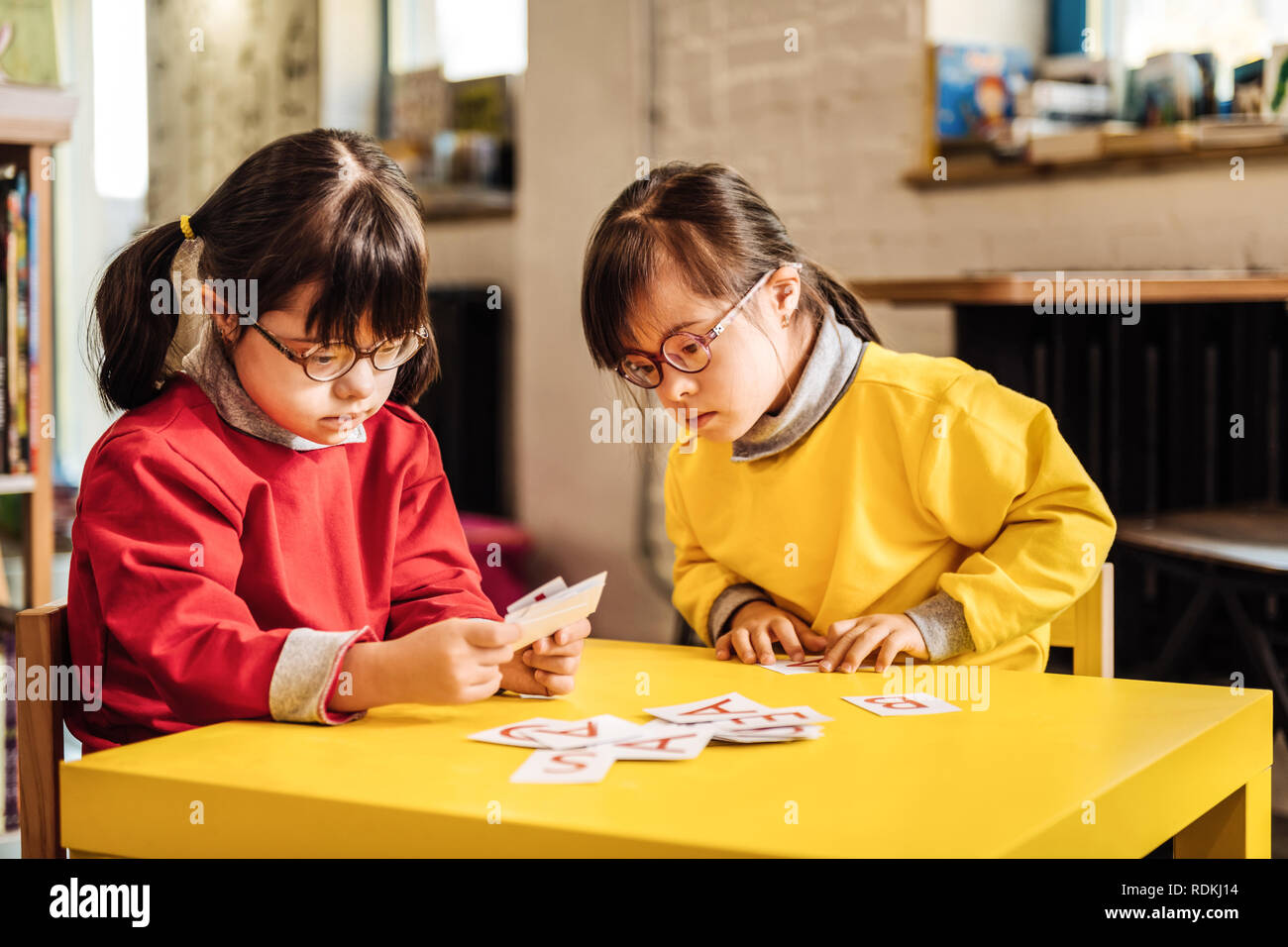 Two sunny children feeling involved in looking at learning cards Stock ...