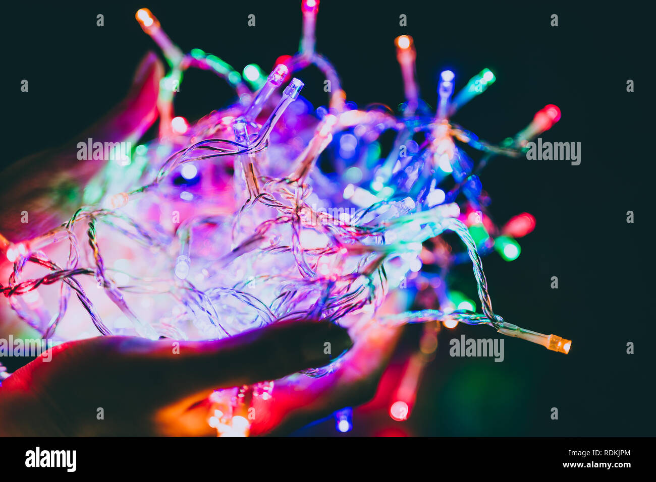 hands holding entangled ball of colorful fairy led lights, concepts of ...