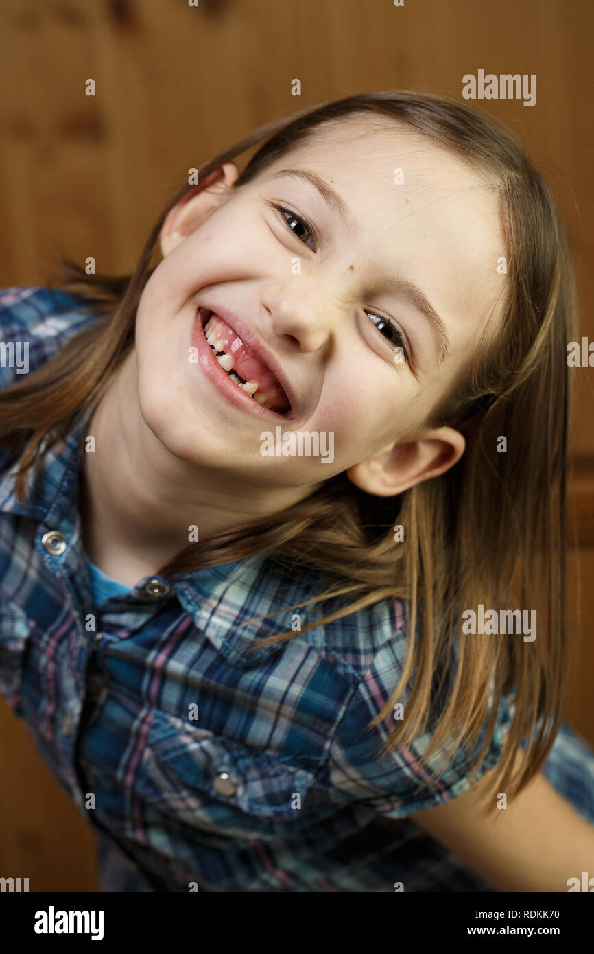 Little girl smiling, showing her loose and missing milk teeth. Playful ...