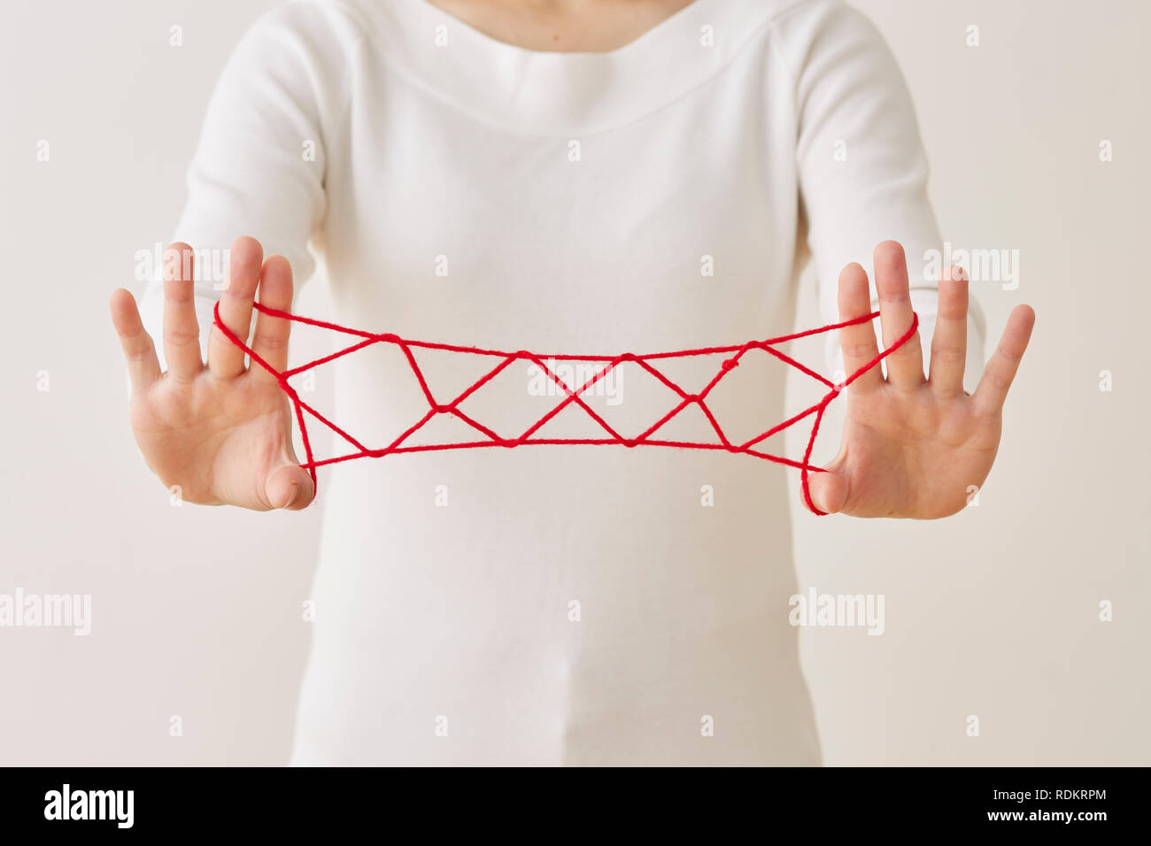 Japanese woman playing with red string Stock Photo - Alamy