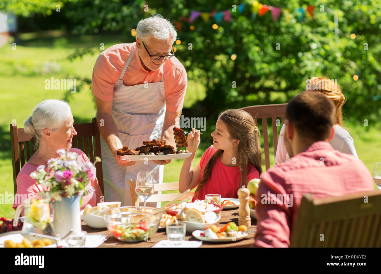 family having dinner or barbecue at summer garden Stock Photo - Alamy