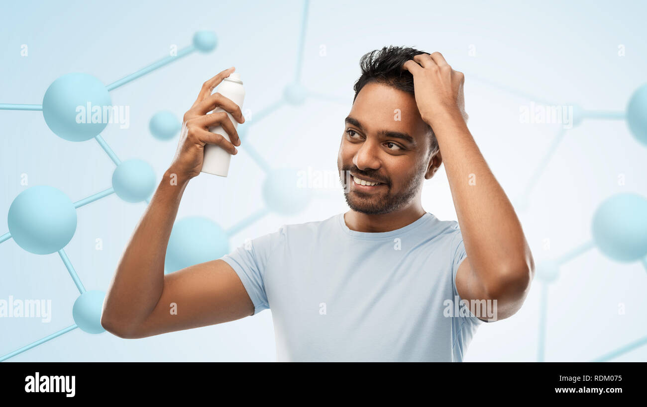 smiling indian man applying hair spray Stock Photo - Alamy