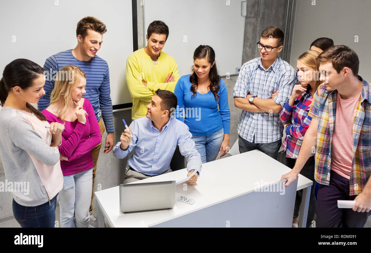 students and teacher with papers and laptop Stock Photo - Alamy