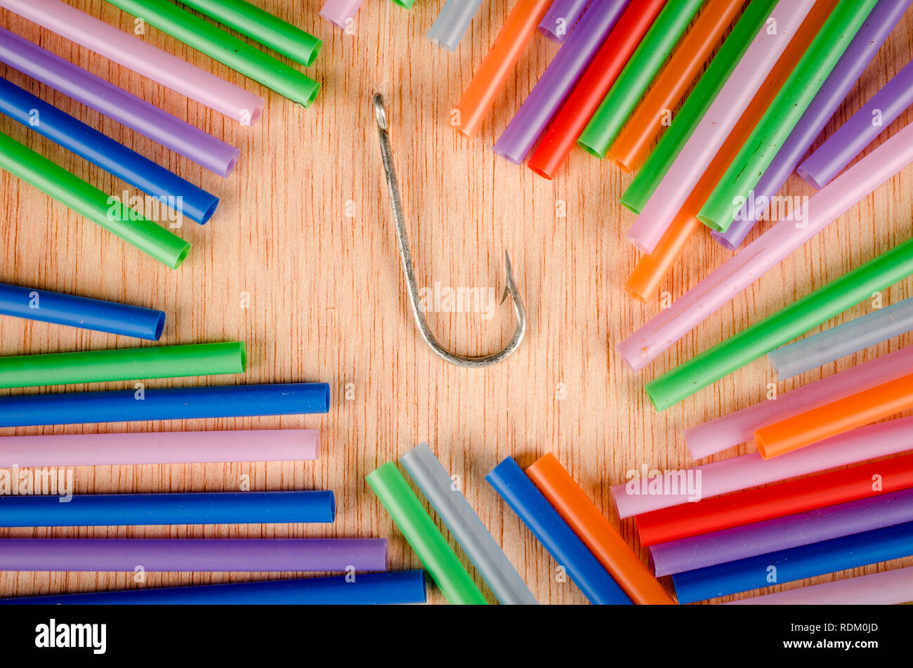 Fishing hook surrounded by drinking straws, a concept of the pollution ...