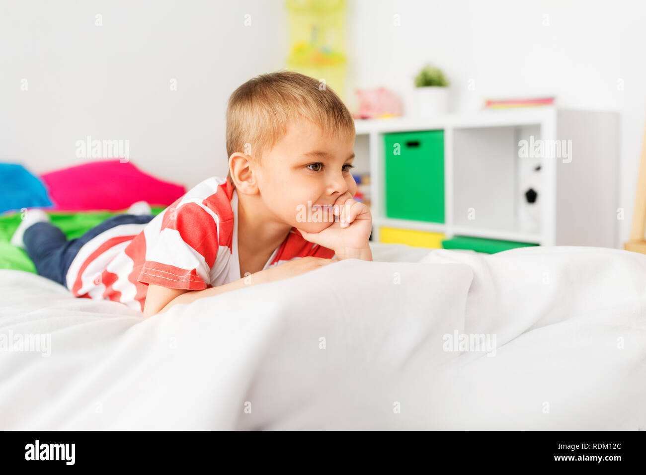 happy little boy lying on bed at home Stock Photo - Alamy