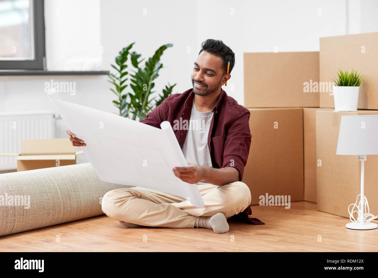 man with boxes and blueprint moving to new home Stock Photo - Alamy