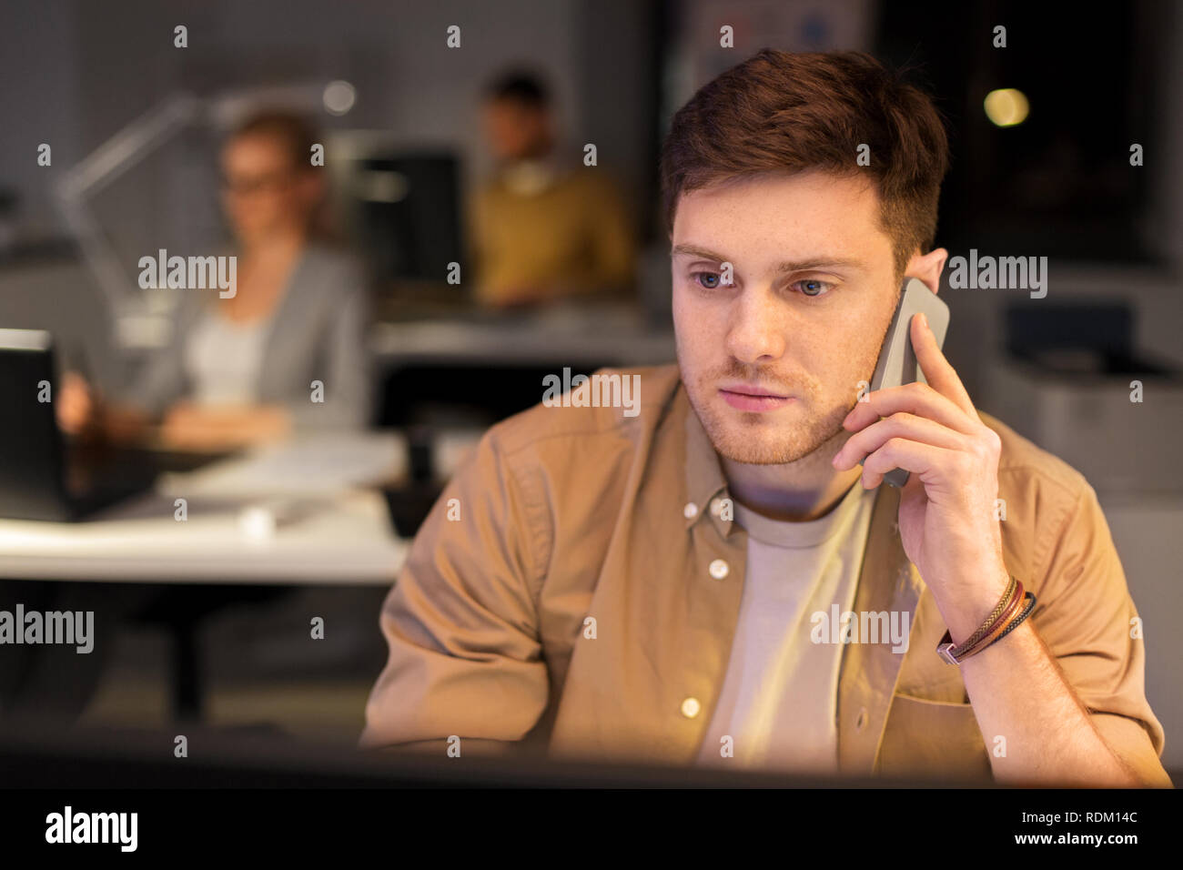 man calling on smartphone at night office Stock Photo - Alamy