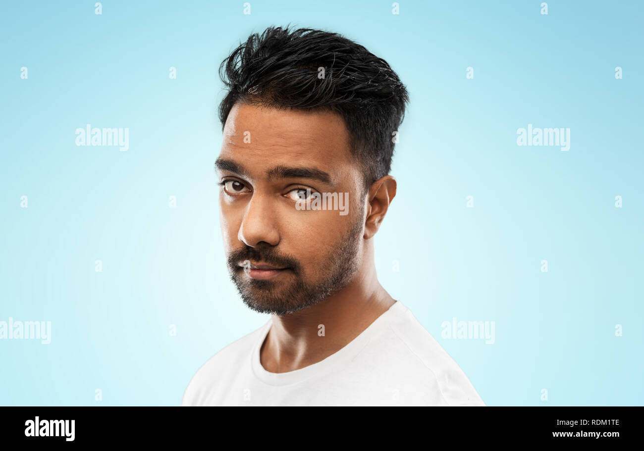 sad young indian man over blue background Stock Photo - Alamy