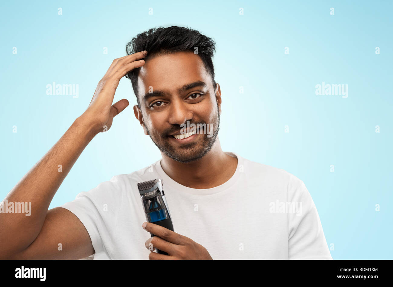 smiling indian man with trimmer touching his hair Stock Photo - Alamy