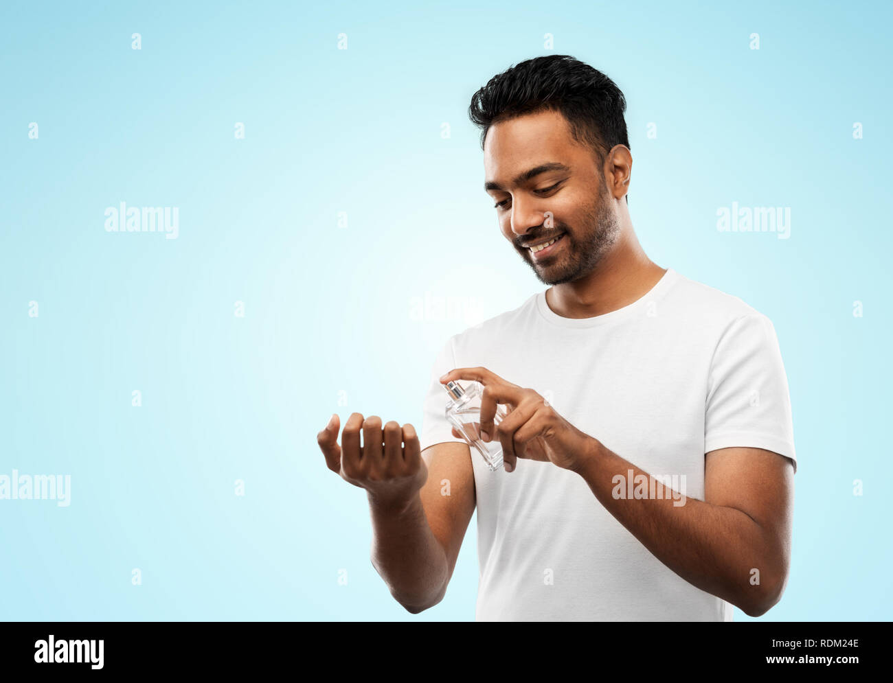 happy indian man with perfume over blue background Stock Photo - Alamy