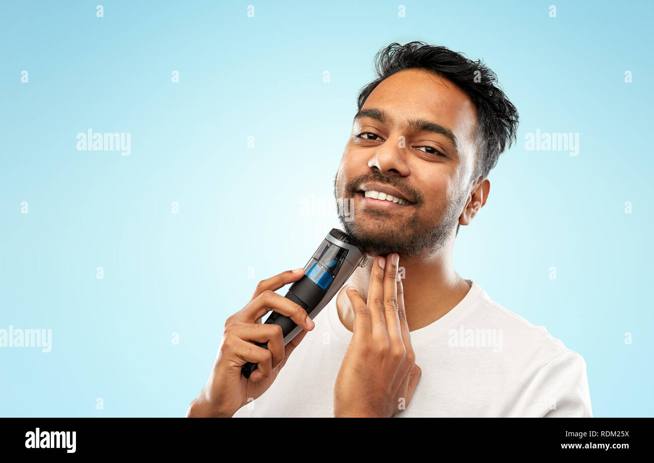 smiling indian man shaving beard with trimmer Stock Photo - Alamy
