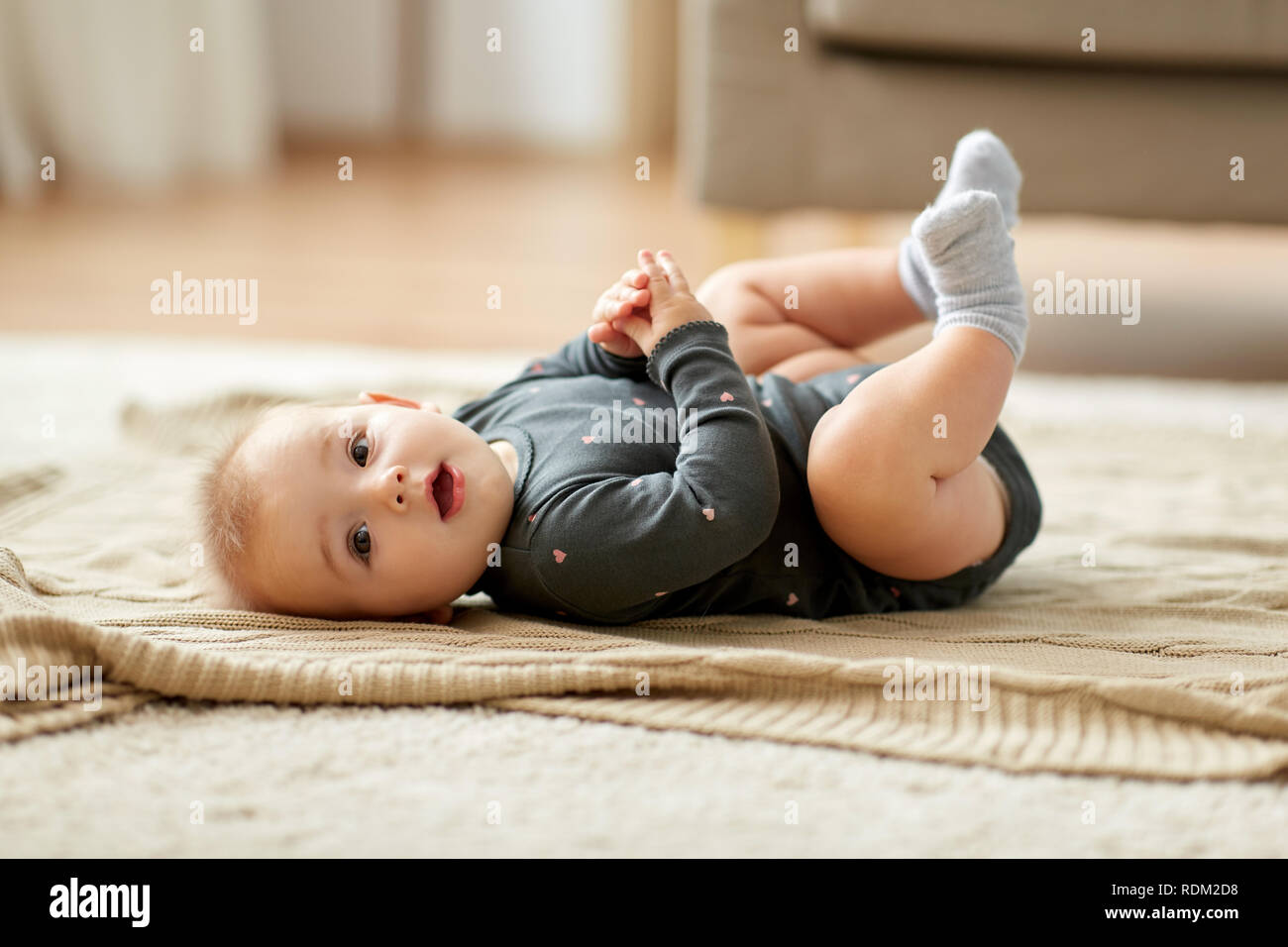 lovely baby girl lying on floor at home Stock Photo - Alamy