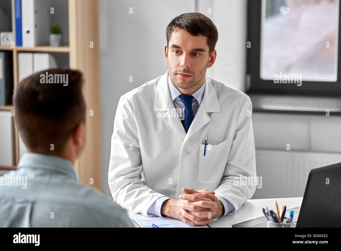 doctor listening to male patient at hospital Stock Photo - Alamy