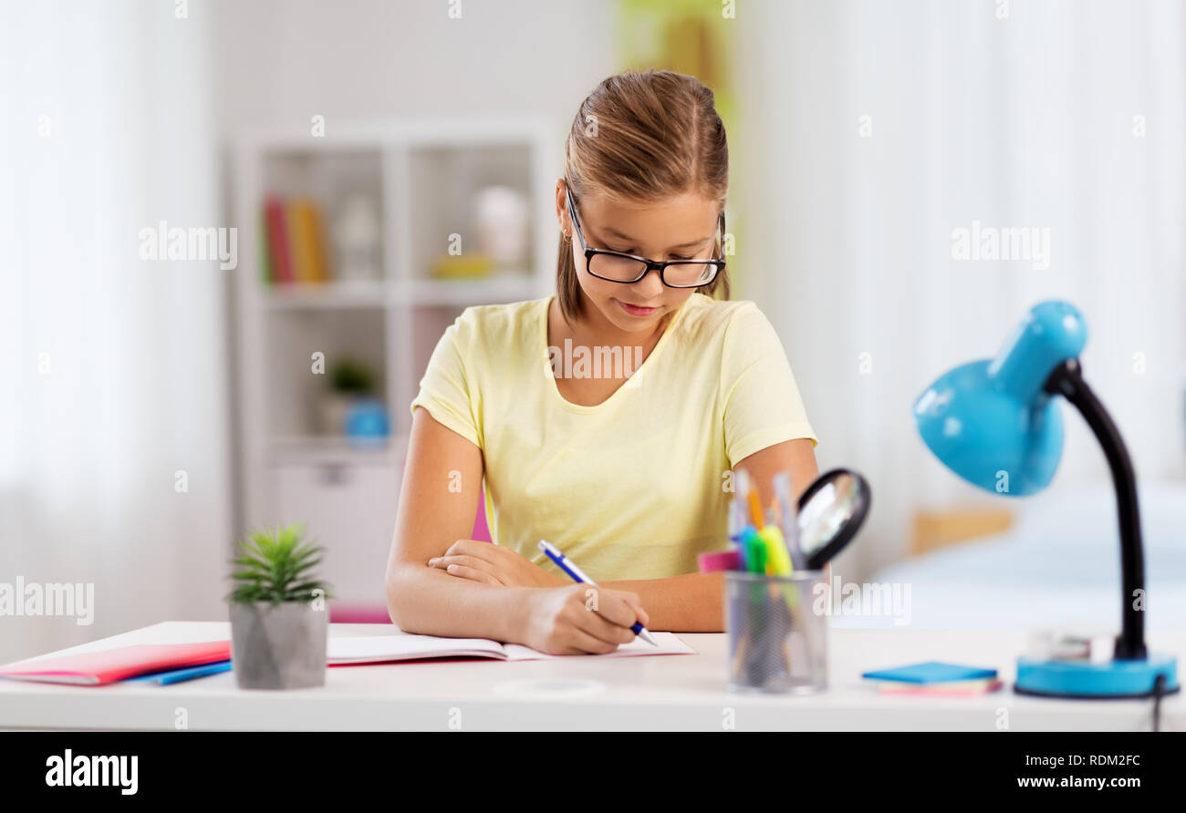 student girl writing to notebook at home Stock Photo - Alamy