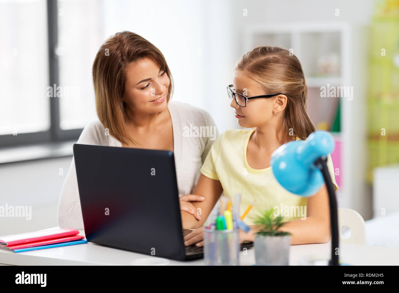 mother and daughter with laptop doing homework Stock Photo - Alamy