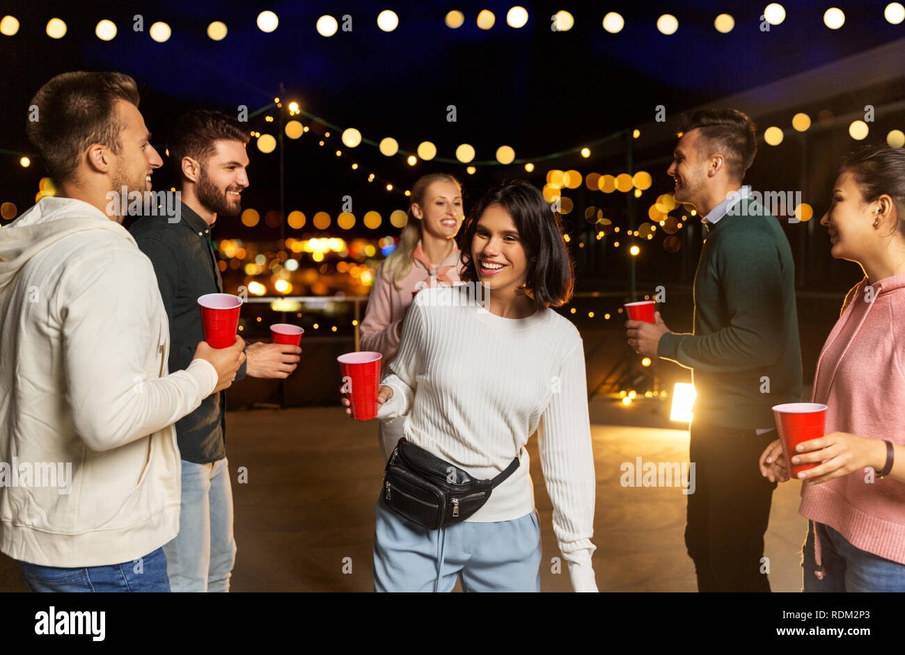 friends with drinks dancing at rooftop party Stock Photo - Alamy