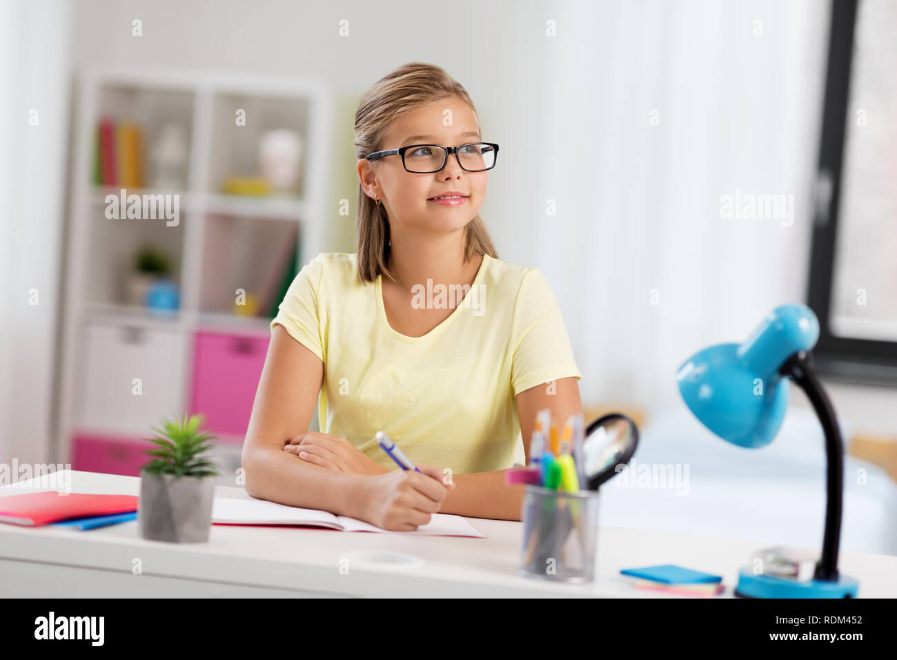 happy student girl doing homework at home Stock Photo - Alamy