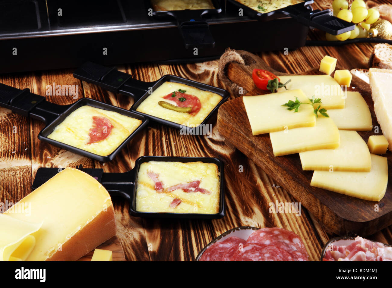 Delicious traditional Swiss melted raclette cheese served in individual ...