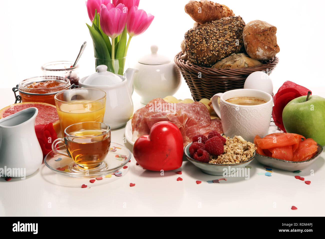 breakfast on table with bread buns, croissants, streamers, coffe and ...