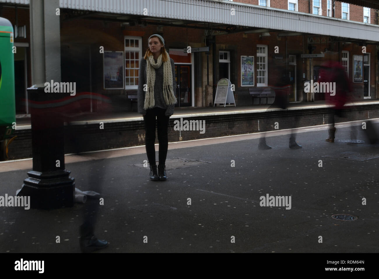 Lady waiting whilst life is busy Stock Photo - Alamy