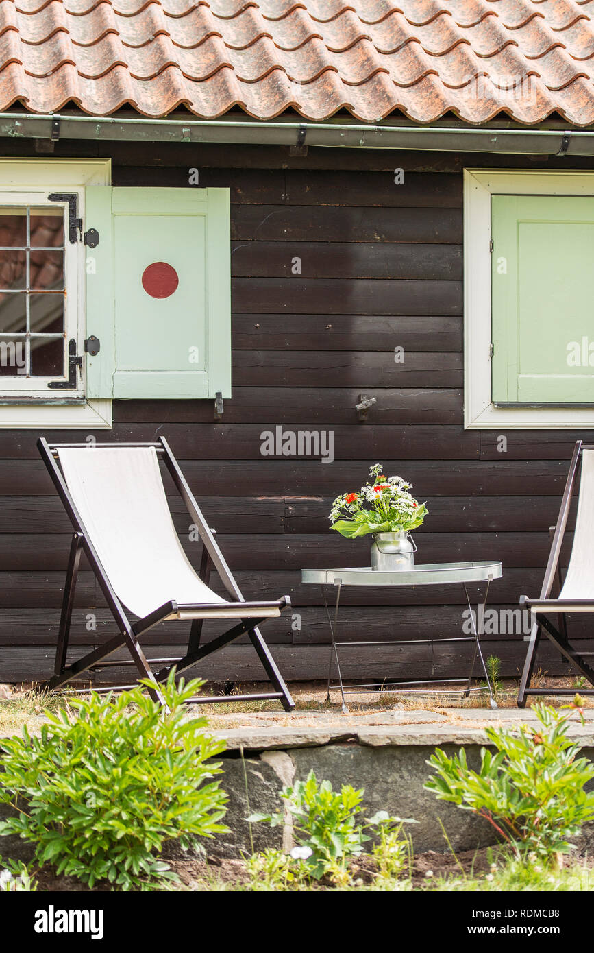 Sun chair in front of wooden house Stock Photo - Alamy