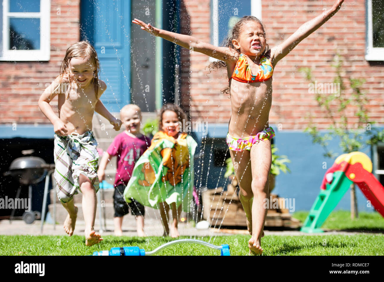 Children playing with water in garden Stock Photo - Alamy