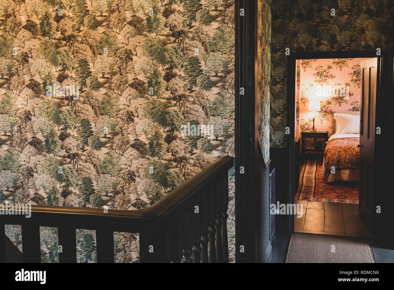 Interior view of landing with wooden banister, wallpaper with green and ...