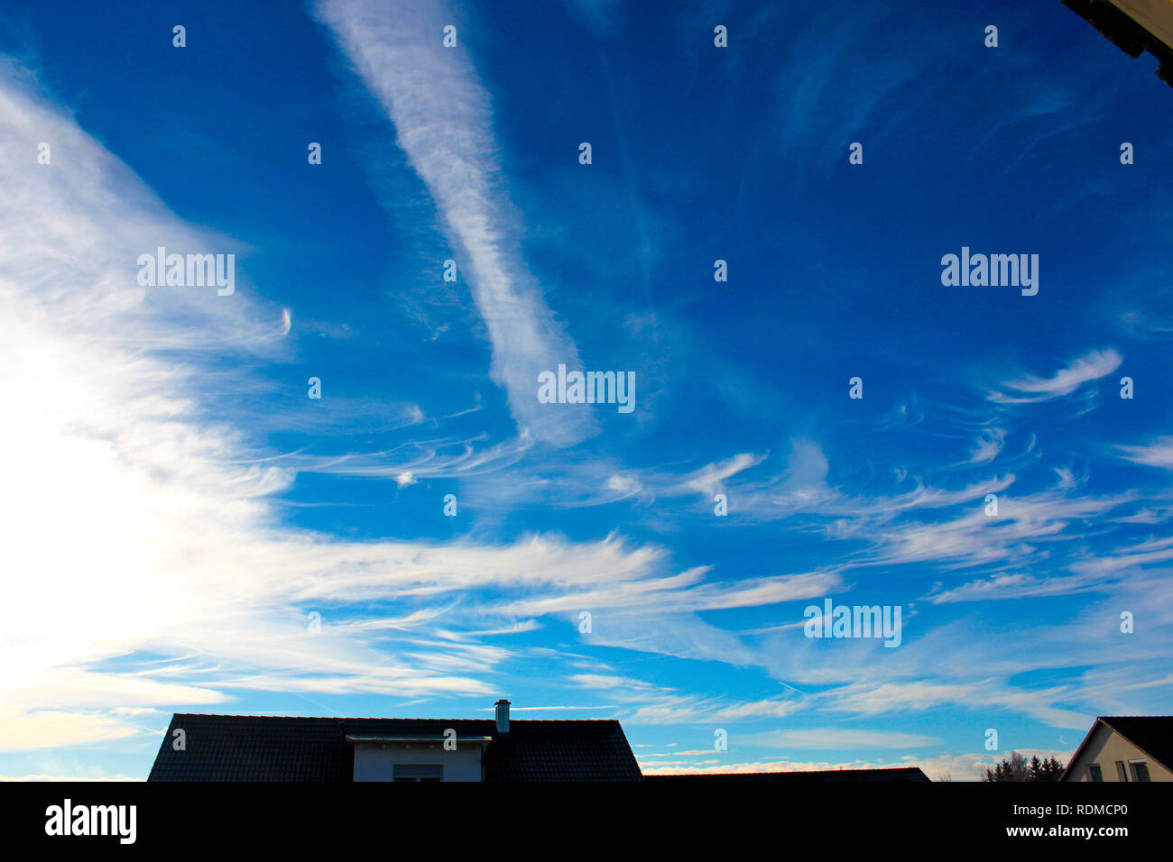 blue sky background with clouds in front of houses Stock Photo - Alamy