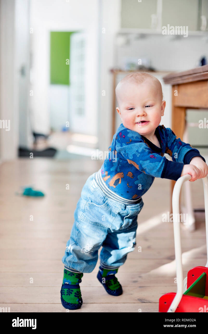 Baby boy pushing wooden cart Stock Photo - Alamy