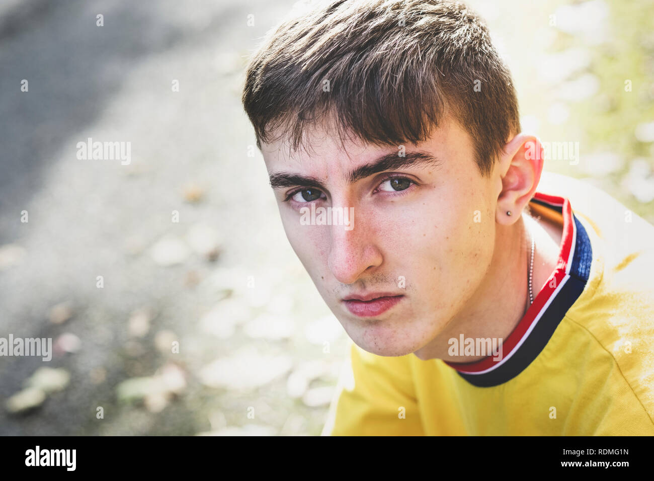 Portrait of young man with short brown hair wearing yellow jumper ...