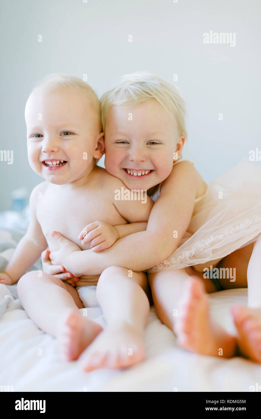 Brother and sister hugging on bed Stock Photo - Alamy