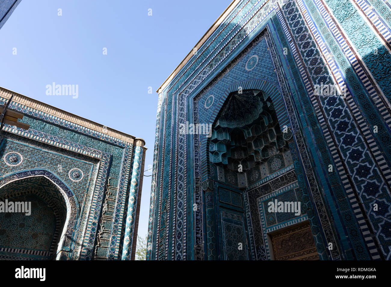 Low angle view of tall arches of an Islamic Madrasa building with blue ...