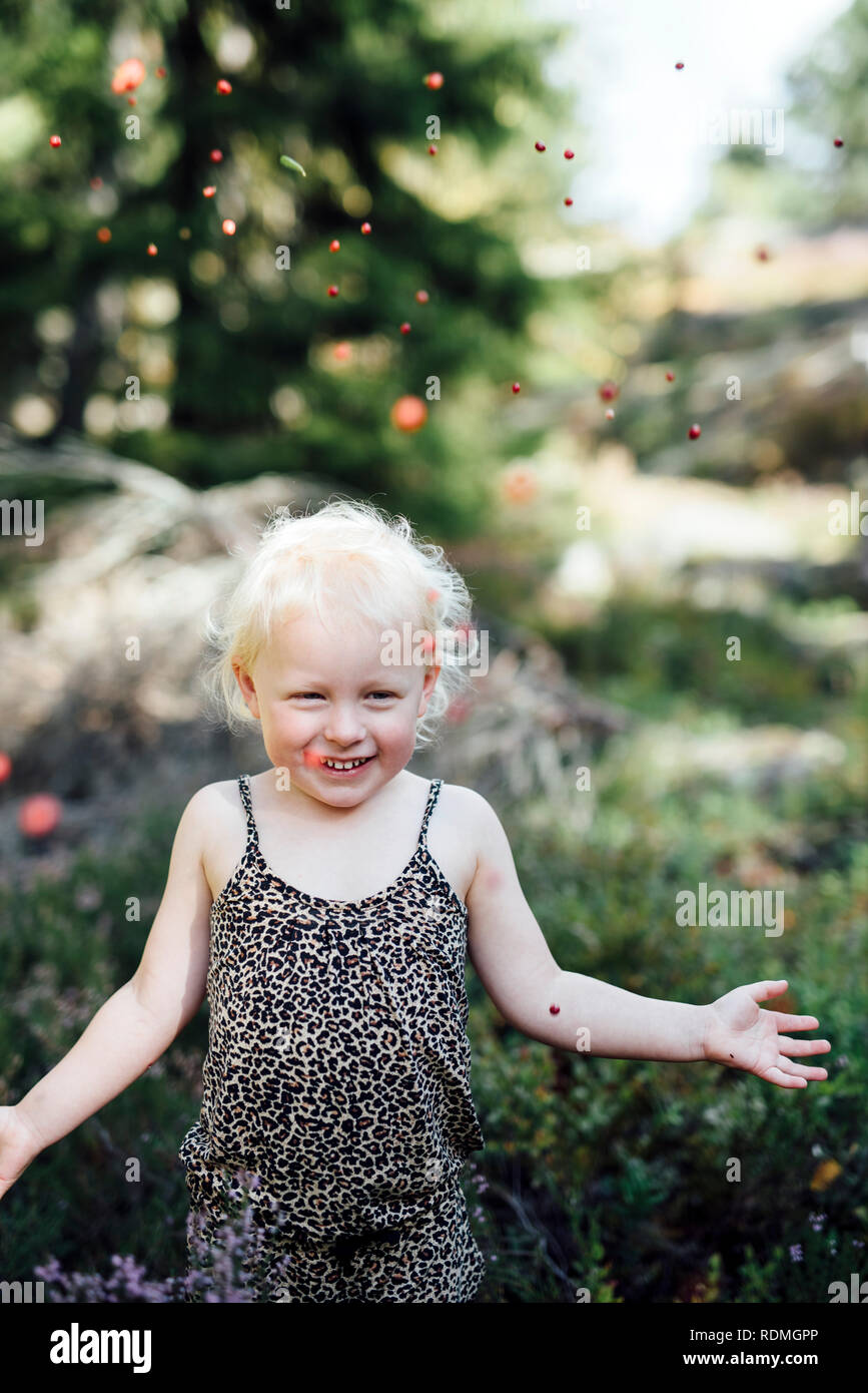 Girl throwing berries in forest Stock Photo - Alamy