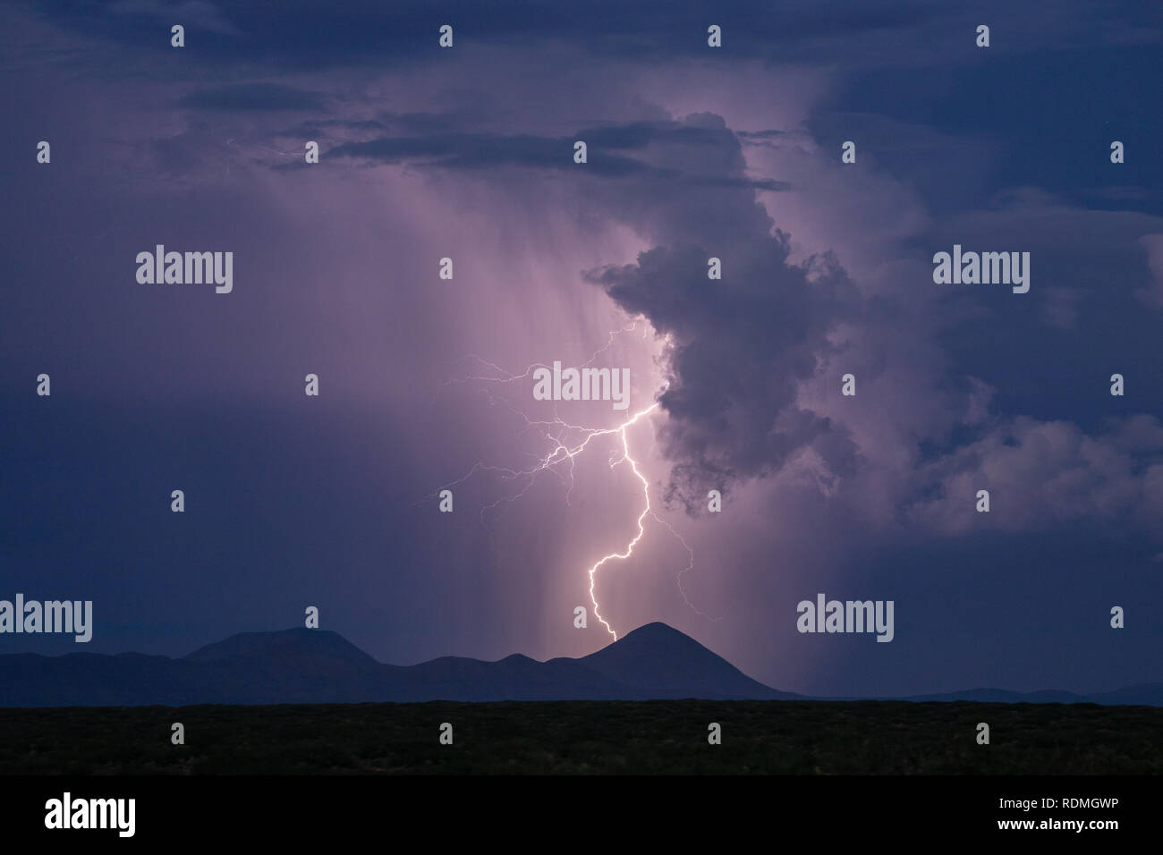 Lightning bolts silhouette Mount Riley and Cox Peak in the Organ ...
