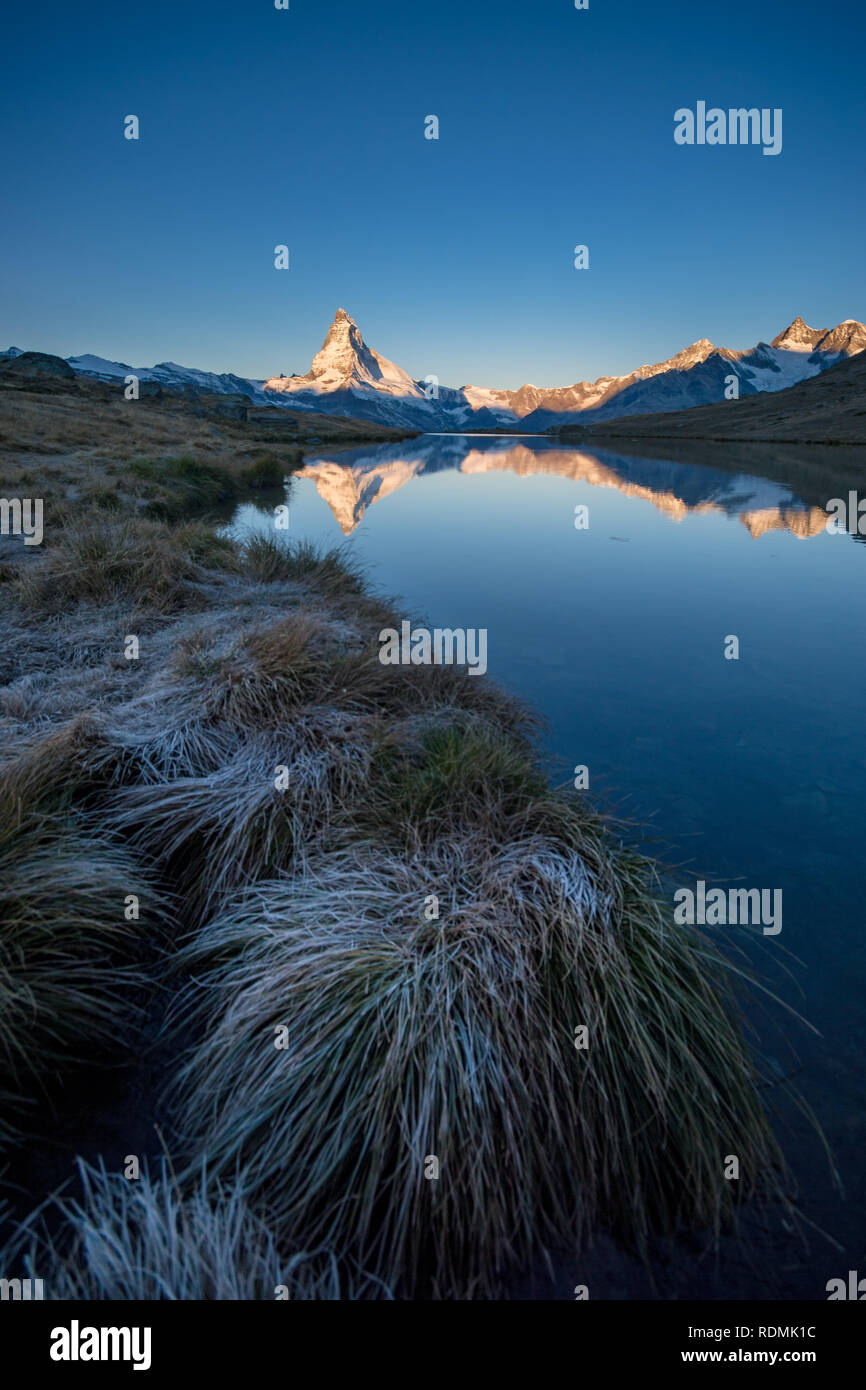 sunrise on Matterhorn and its reflection in a mountain lake Stock Photo ...
