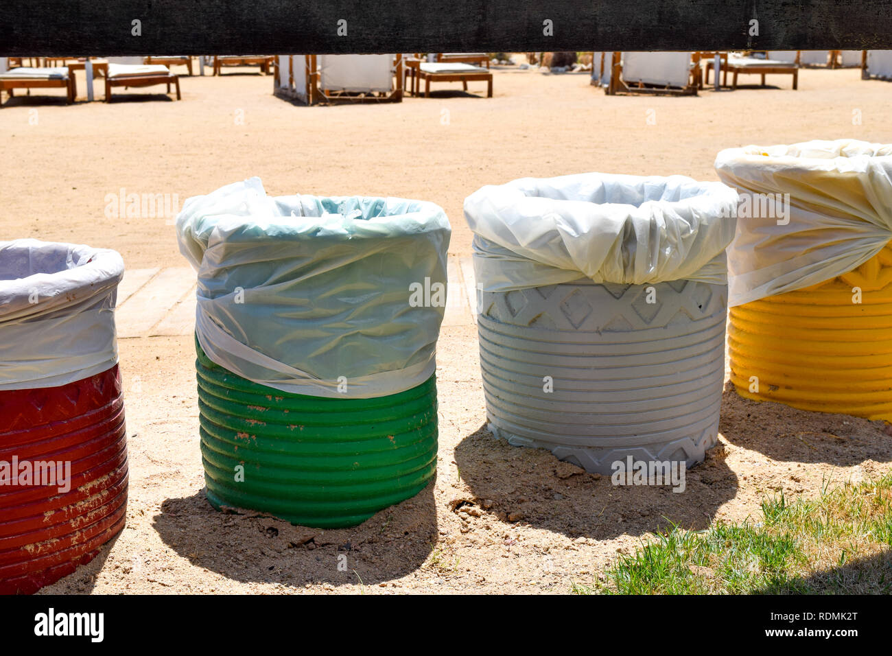 Four colors of rubbish cans on the beach, red, green, white and yellow ...