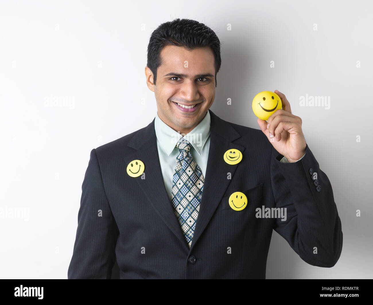 PORTRAIT OF CORPORATE EXECUTIVE wearing smile badges and holding a ...