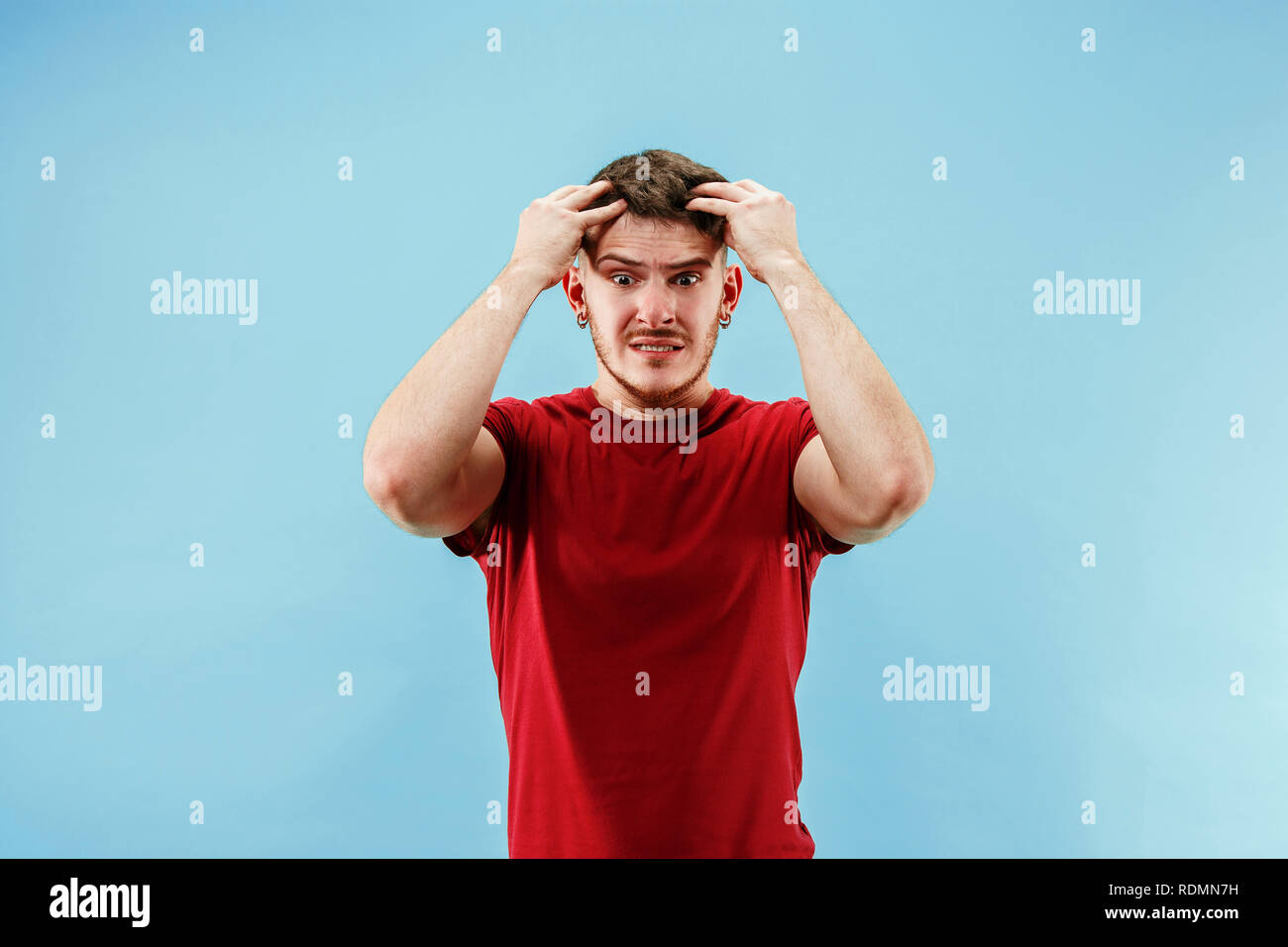 Young boy with a surprised unhappy failure expression bet slip on blue ...