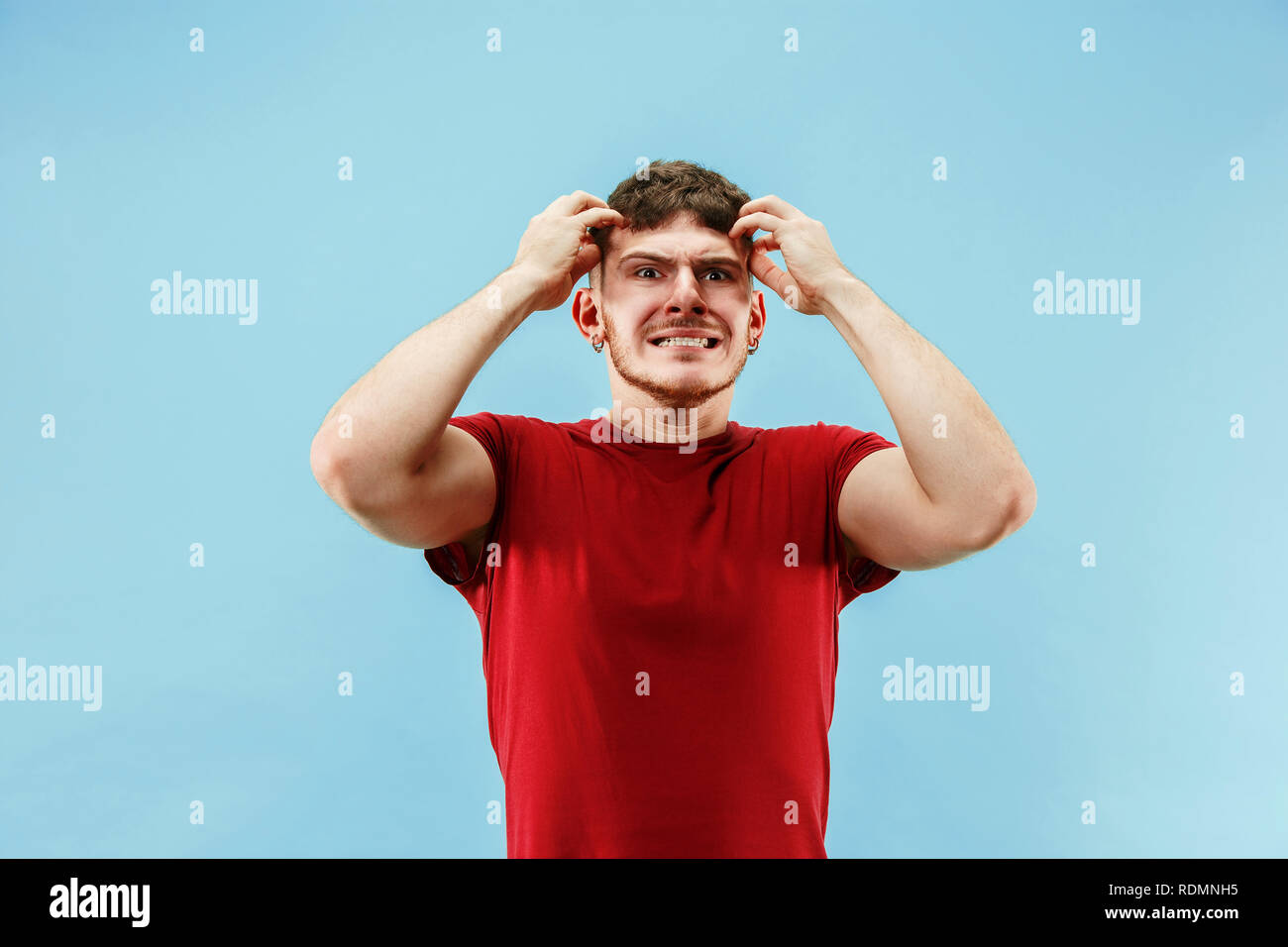 Young boy with a surprised unhappy failure expression bet slip on blue ...