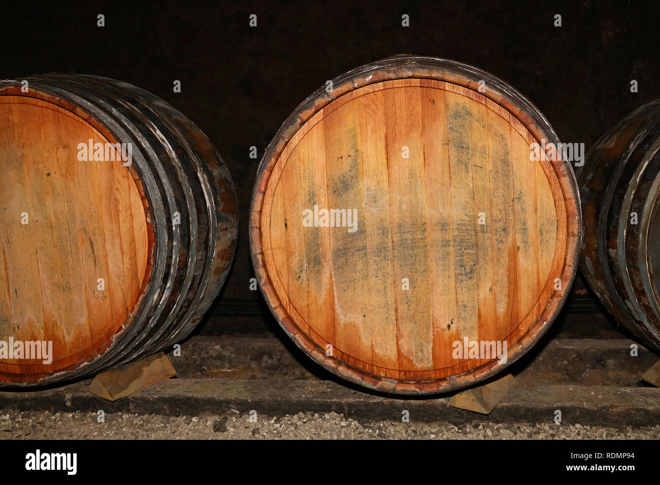 Close up rows of traditional aged natural oak wood wine barrels in ...