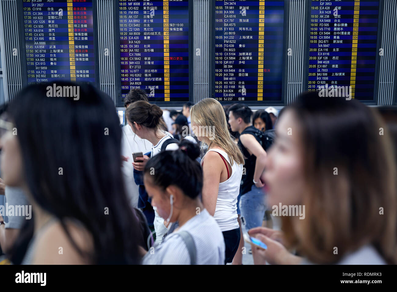 Passengers are waiting inside an airport terminal in front of an ...