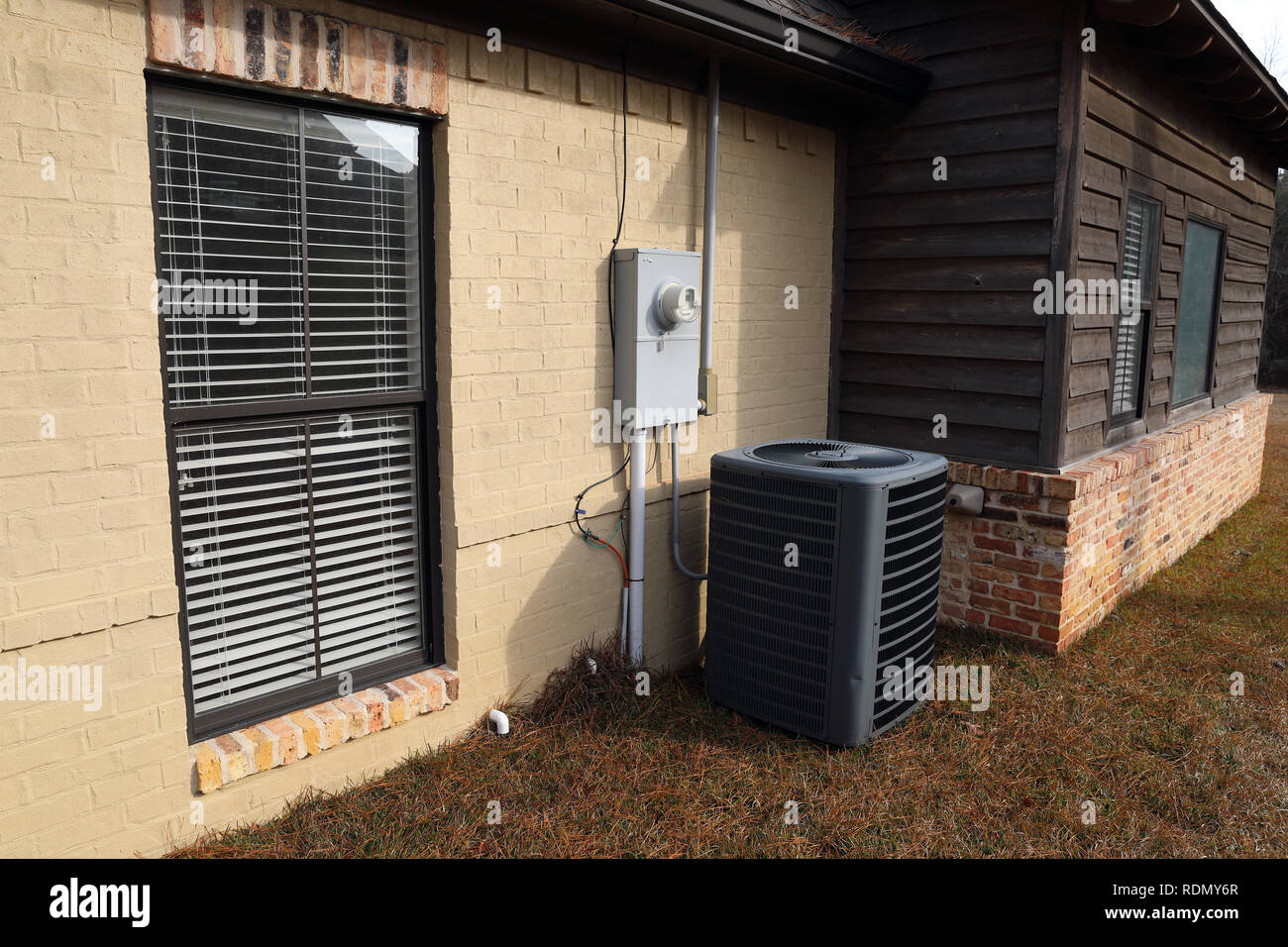 Gray Air Conditioner condenser compressor unit next to painted brick ...