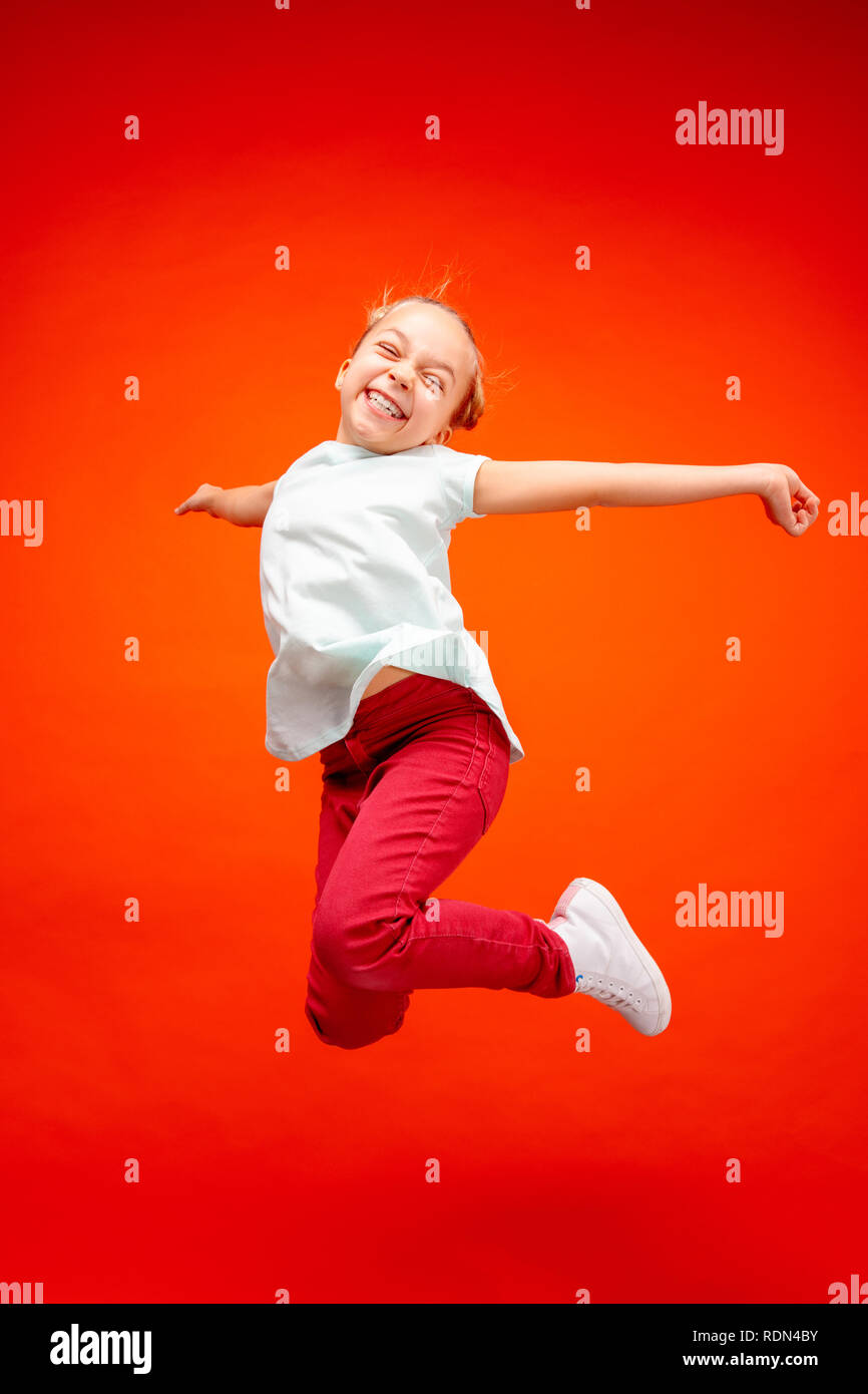 Young scared surprised caucasian teen girl jumping in the air, isolated ...