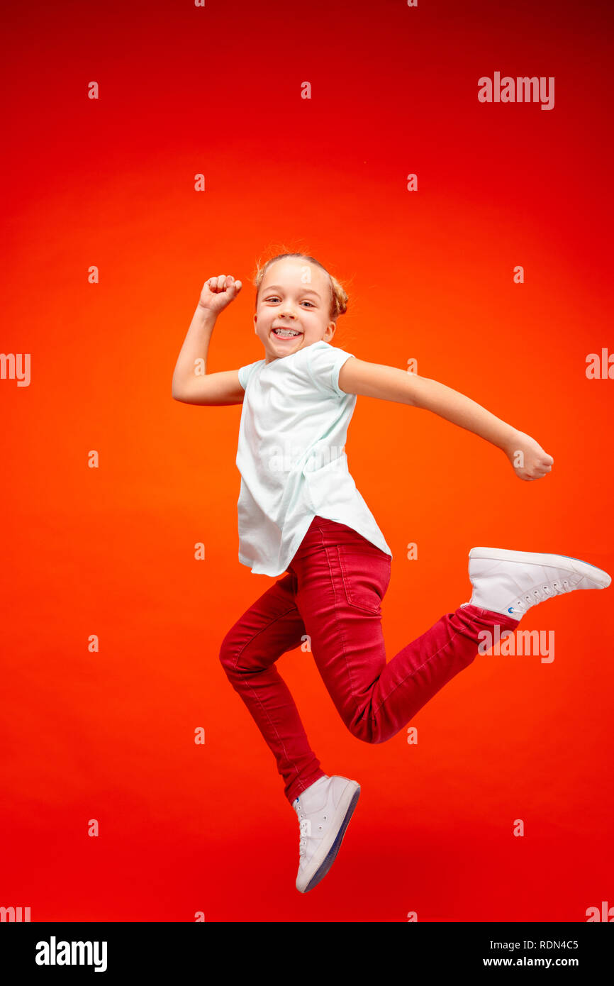 Young scared surprised caucasian teen girl jumping in the air, isolated ...