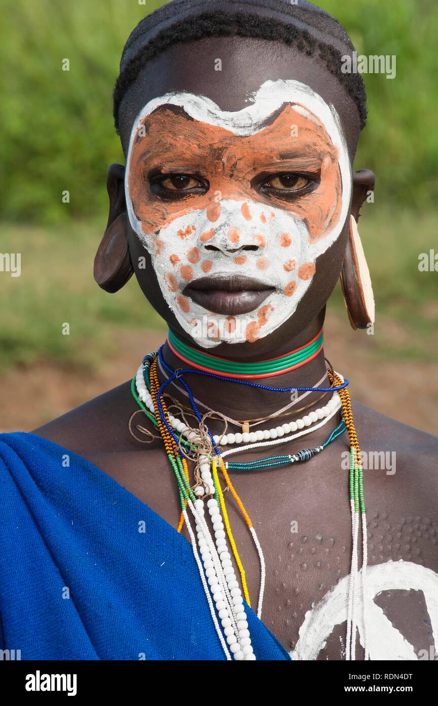 Young Surma woman with facial and body painting and ear plates, Kibish ...