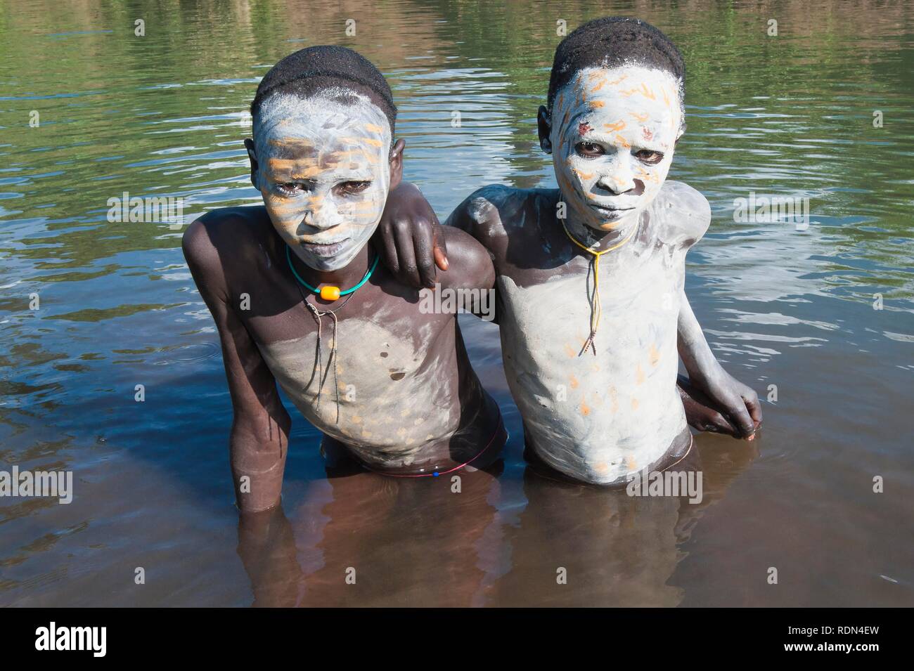 Surma men with body paintings in river hi-res stock photography and ...
